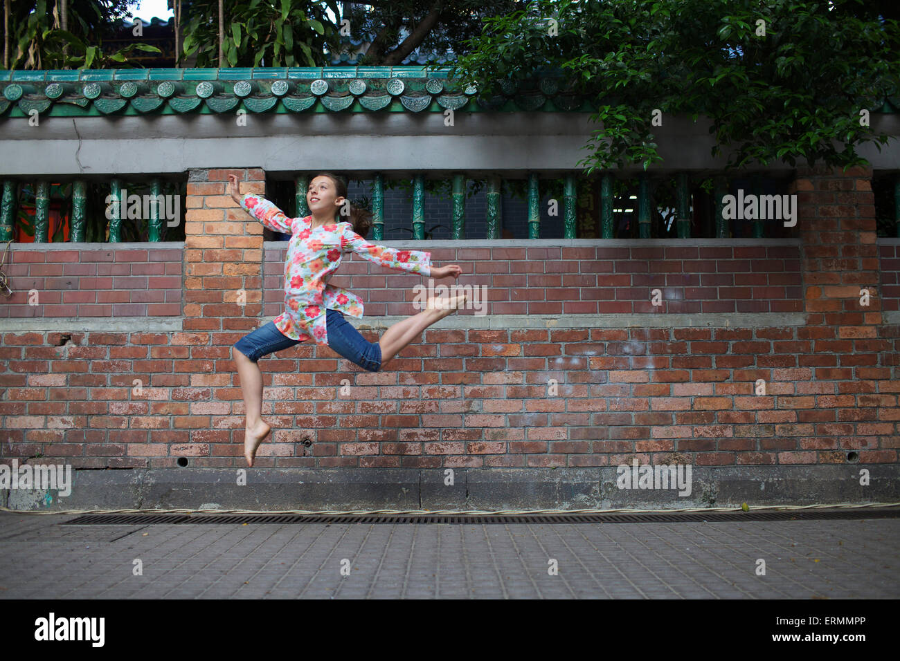 A young girl jumping in mid-air in an urban area; Hong Kong Stock Photo ...