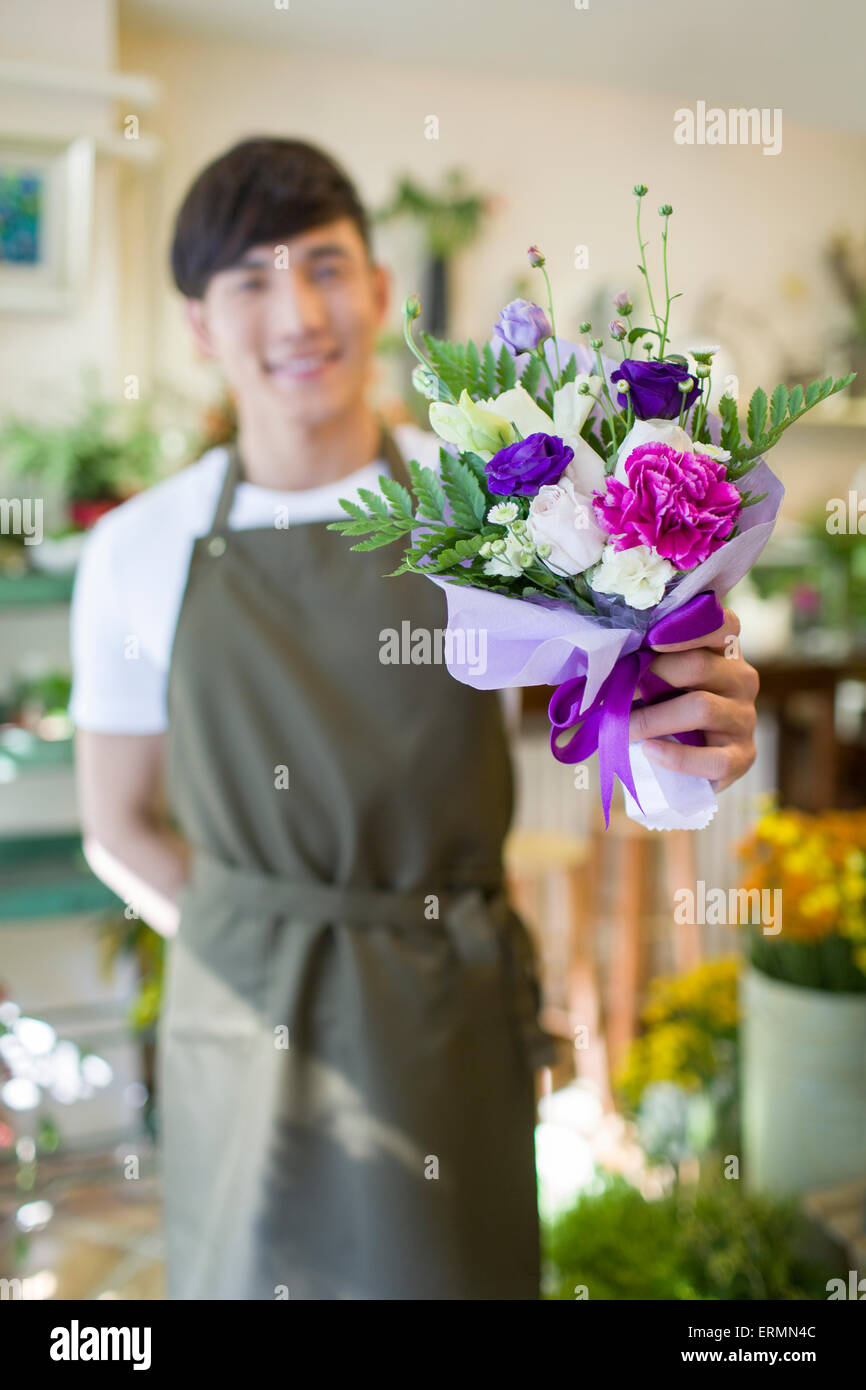 Male florist holding flower bouquet Stock Photo - Alamy
