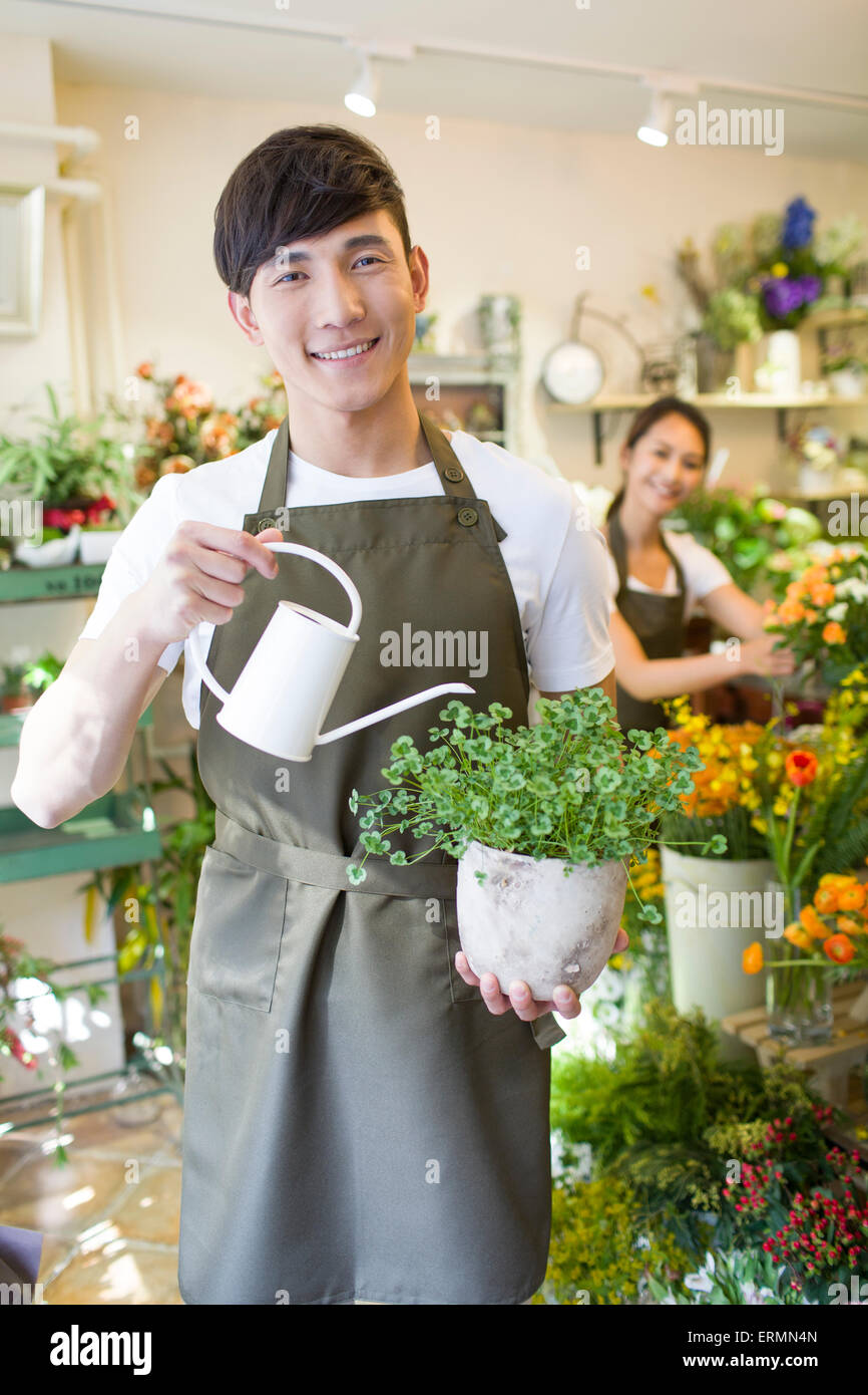 Male florist watering plants in flower shop Stock Photo - Alamy