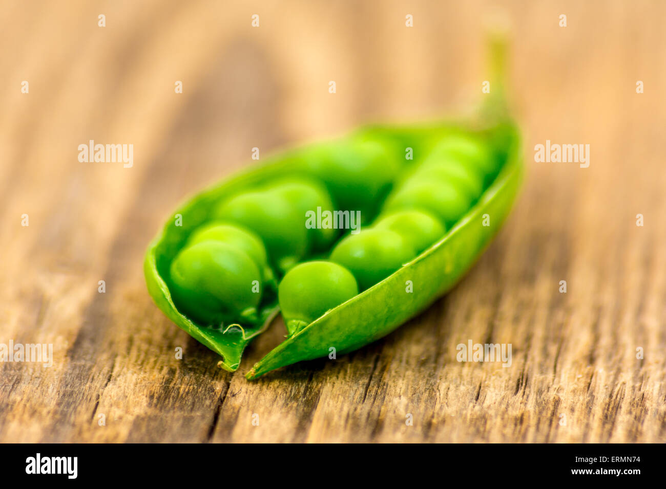 Many raw open pea on wood table Stock Photo - Alamy
