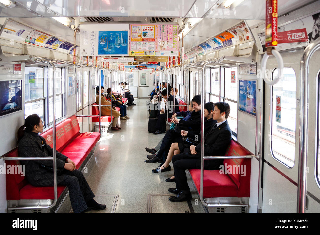Interior of Japanese commuter railway carriage with passengers sitting ...