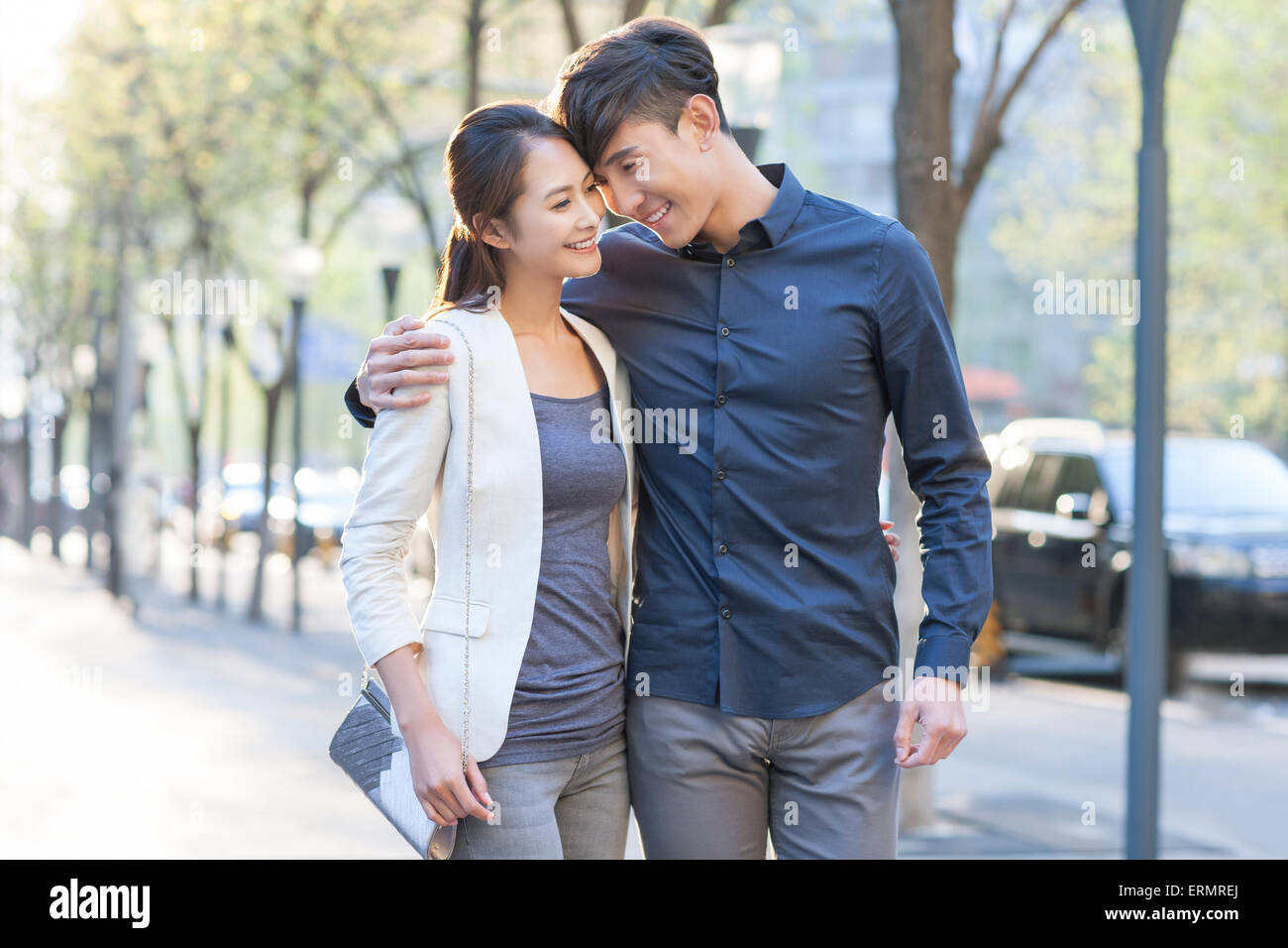 Young couple walking on sidewalk Stock Photo - Alamy