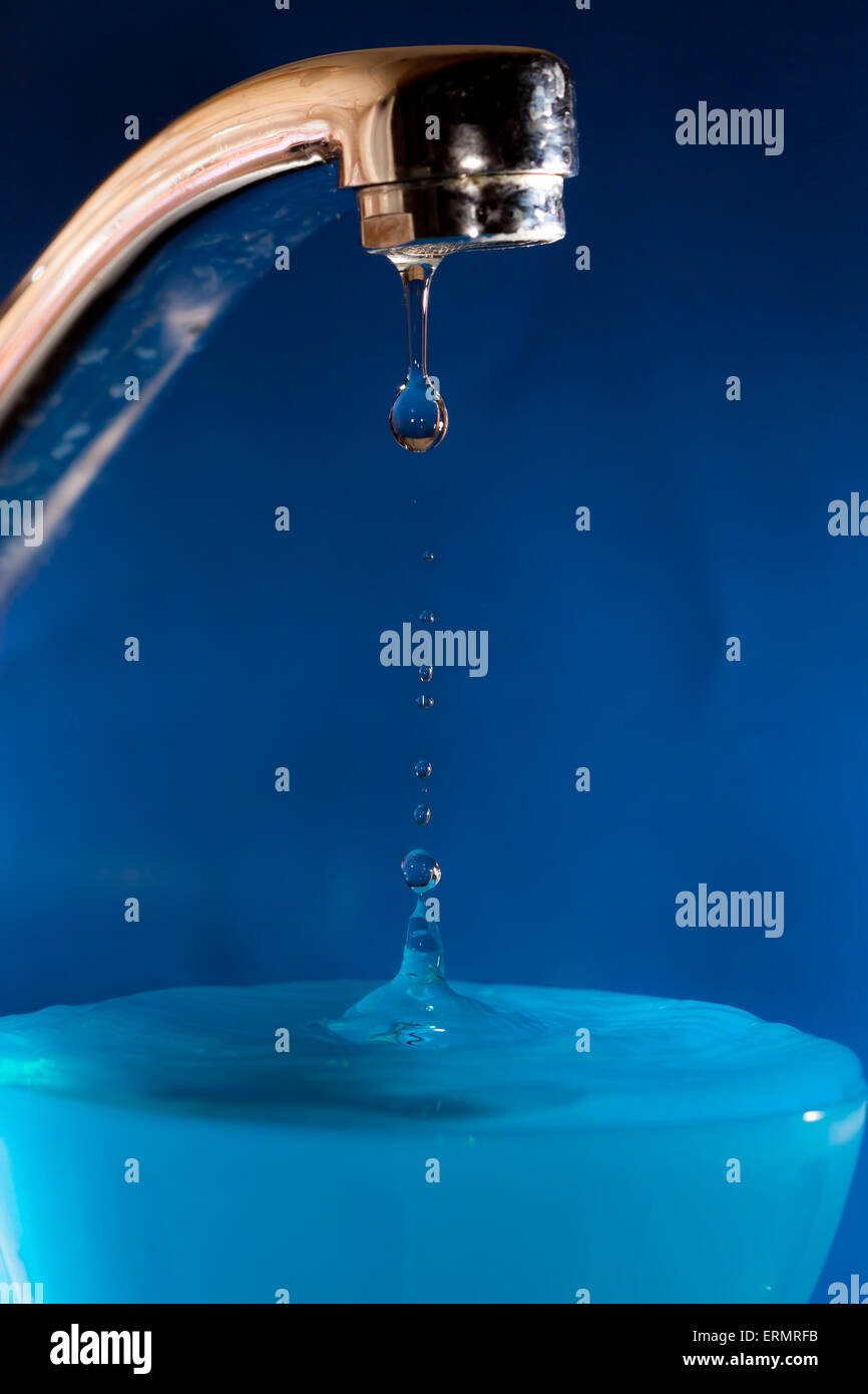 Water tap with drop, on the blue background Stock Photo - Alamy