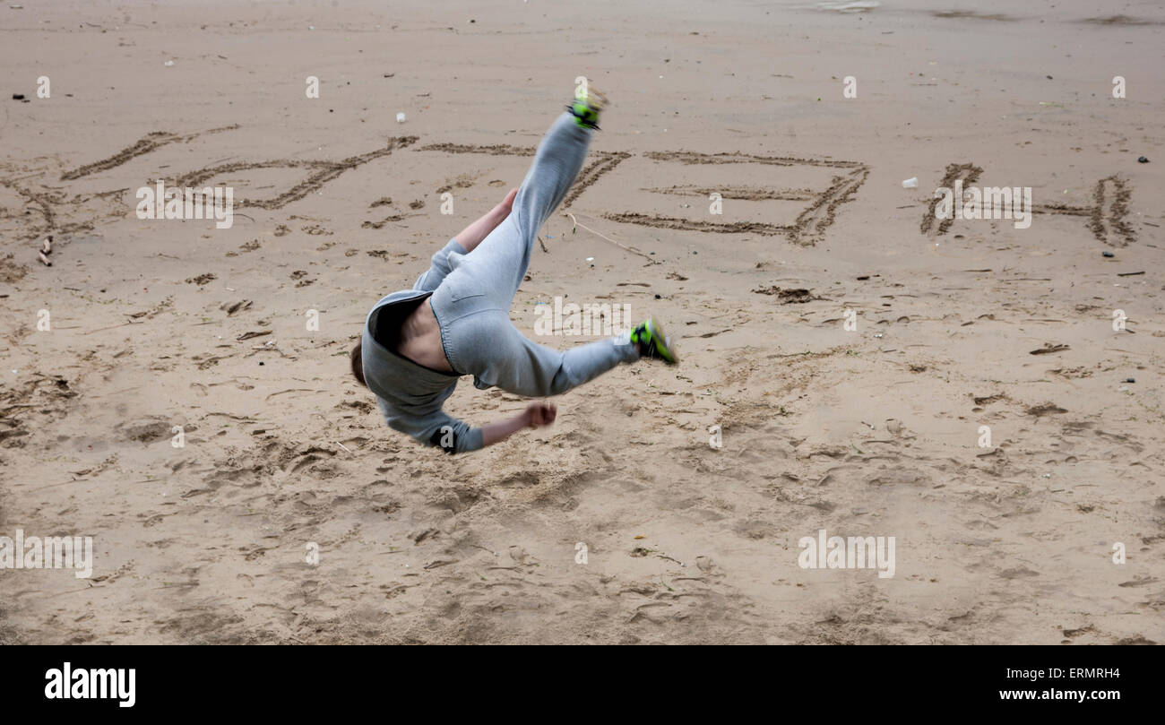 Man jumping and spinning on sand with Help marked Stock Photo - Alamy