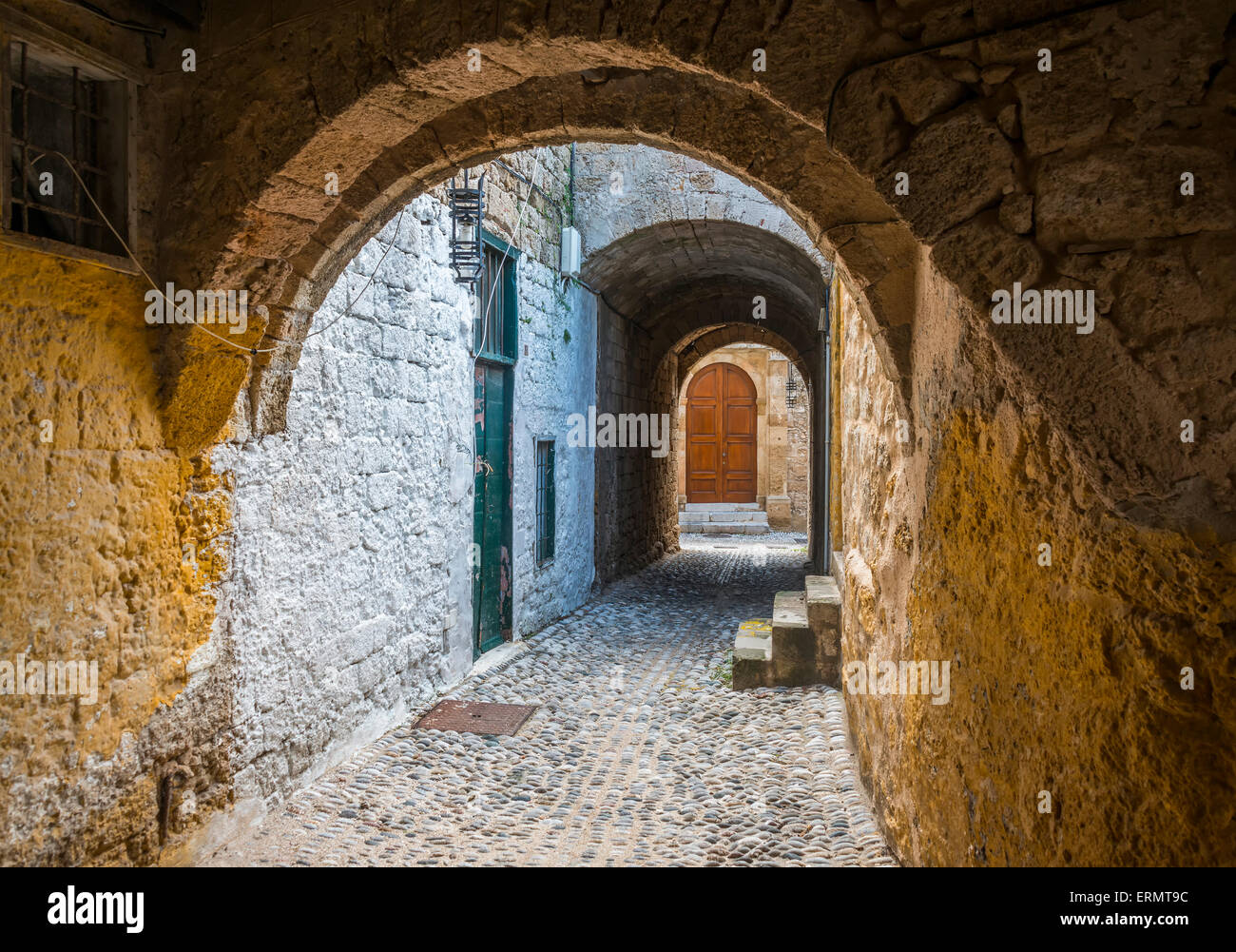 Medieval arches along a cobbled street in the old town of Rhodes ...