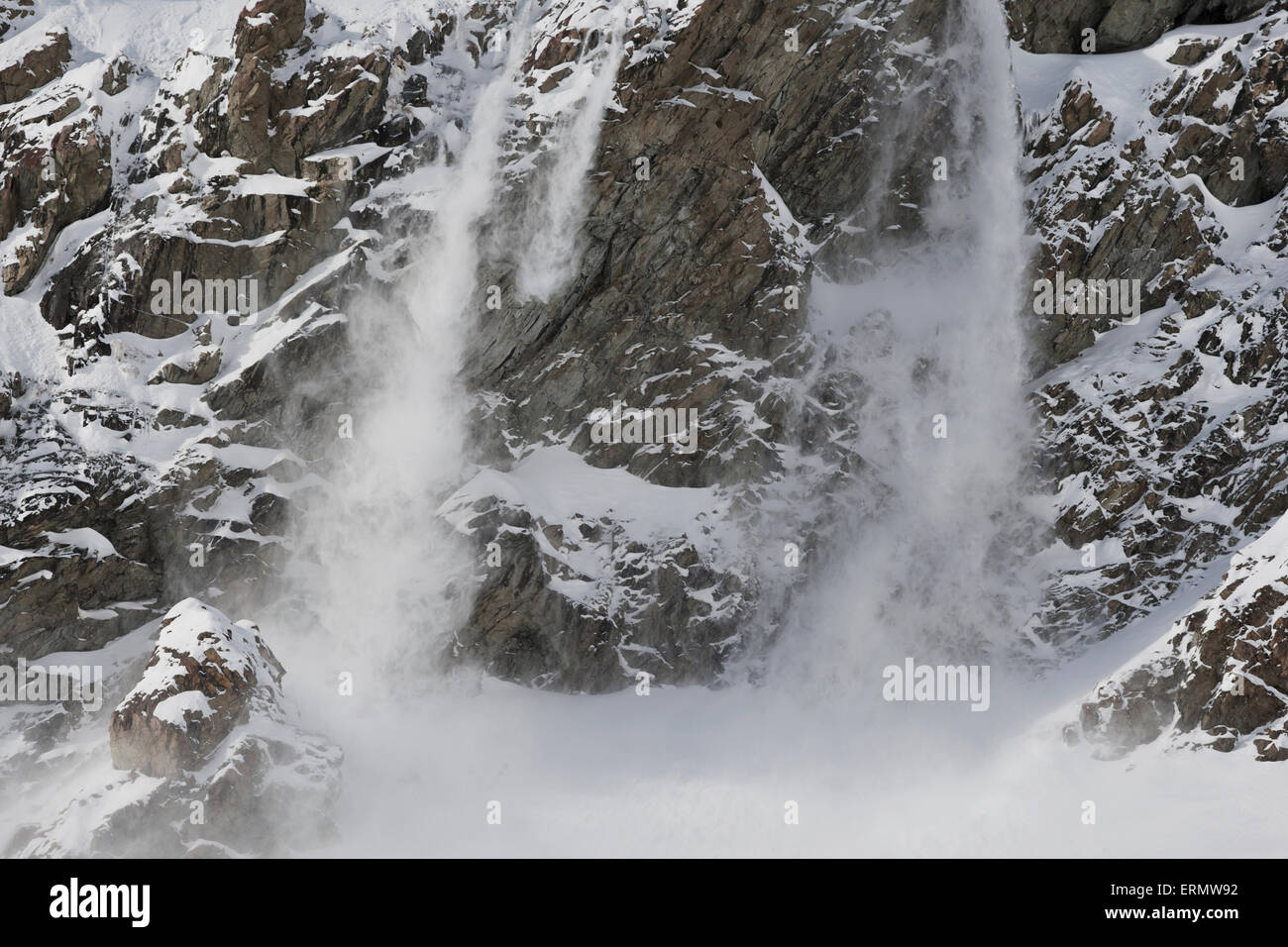 View of an avalanche falling down steep cliff walls on a mountain ...