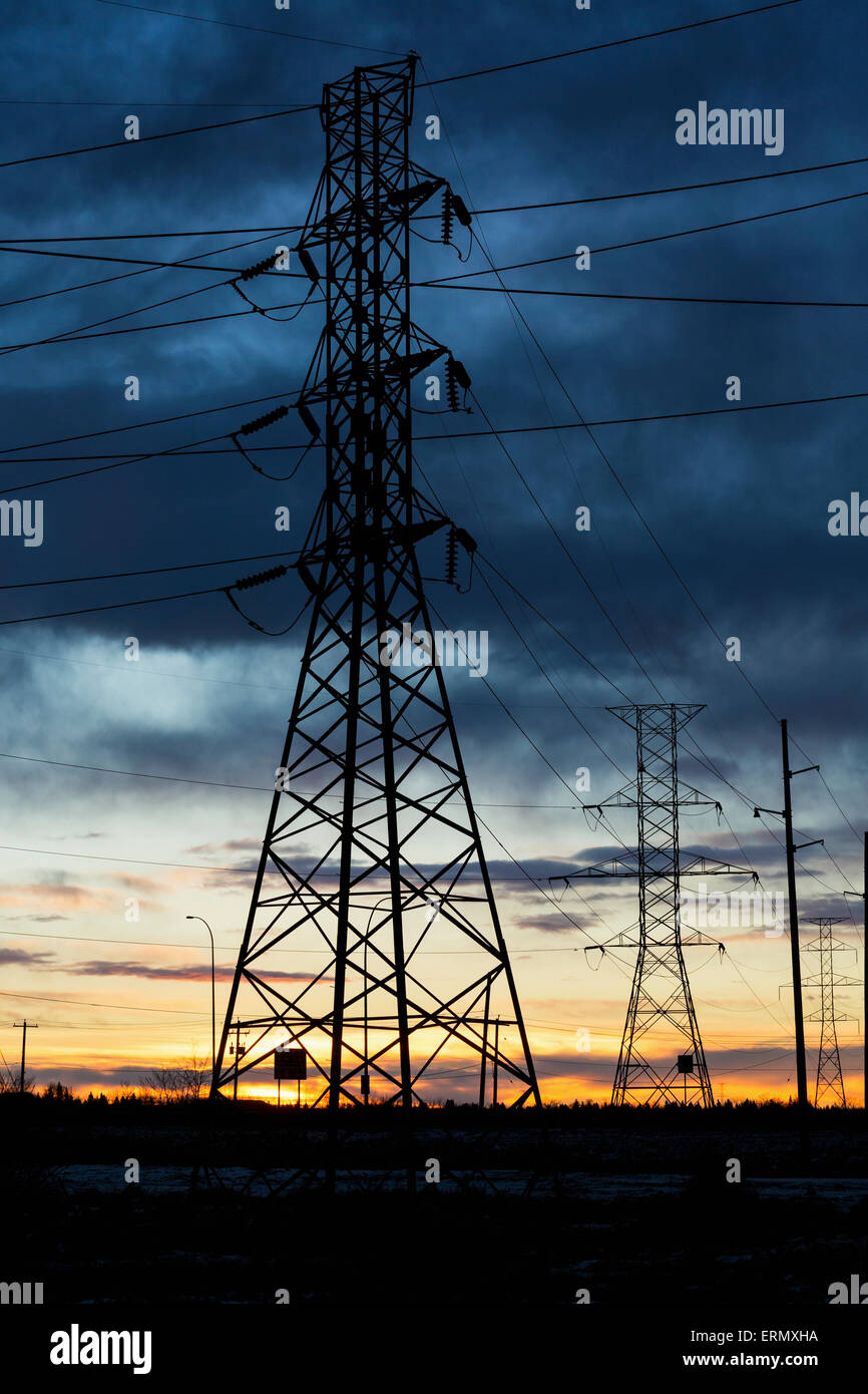 Silhouette of large metal powerline towers with glowing sky; Calgary ...