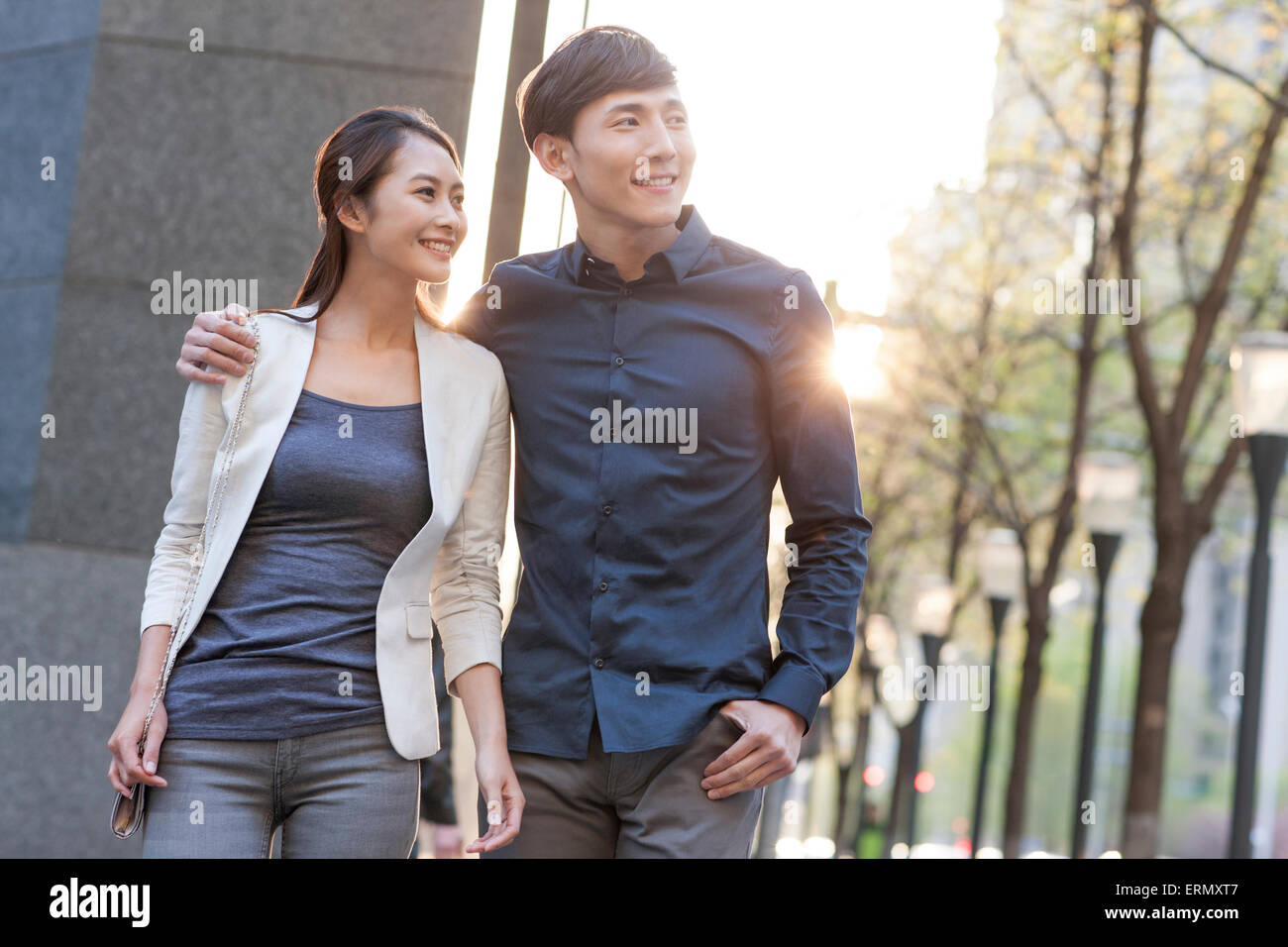 Young couple walking on sidewalk Stock Photo - Alamy