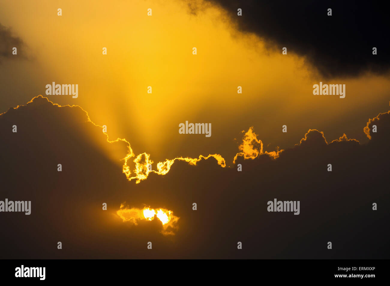 Close up of the sun coming through clouds with rays beaming up at ...