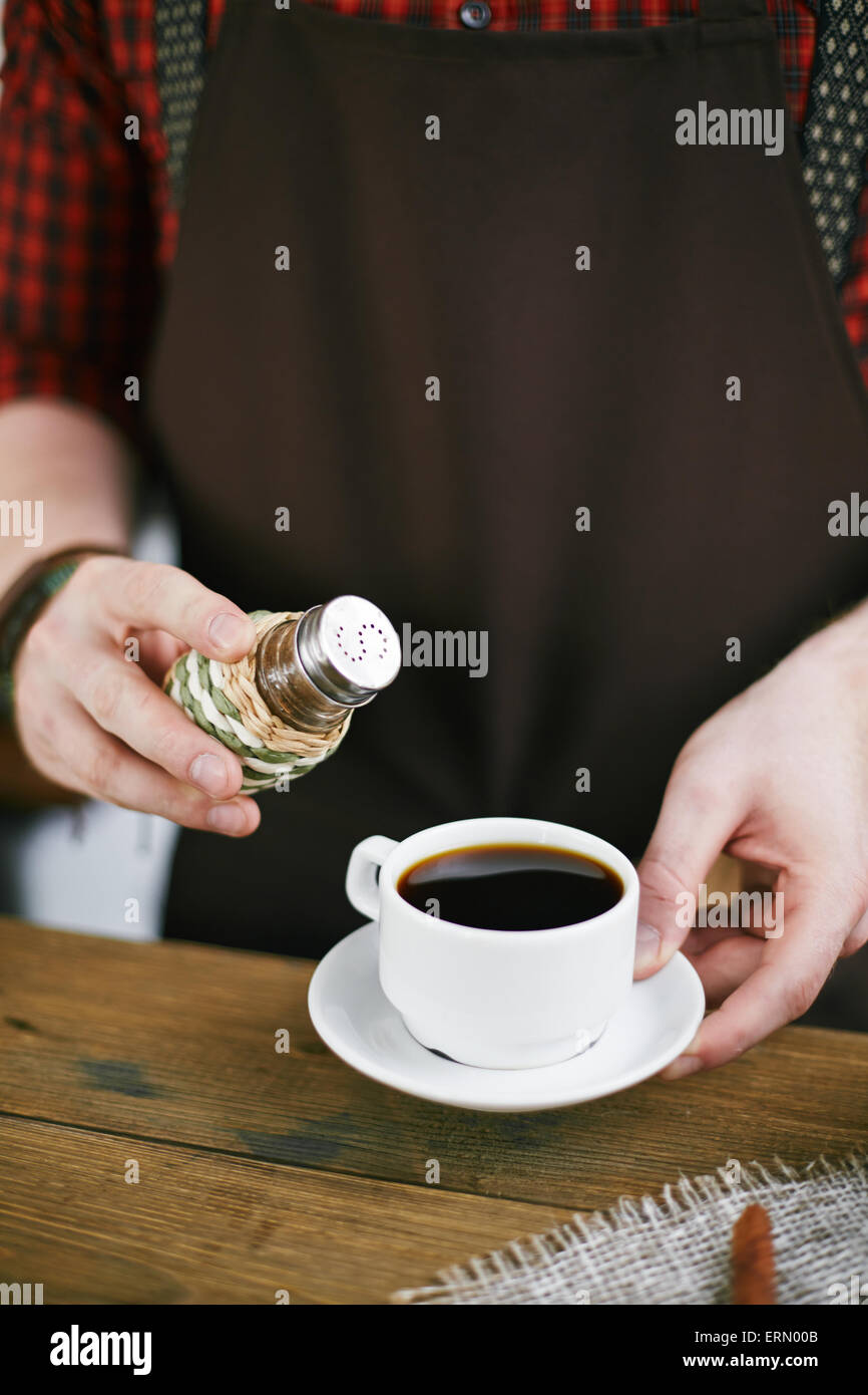 Hands of barista adding salt in black coffee Stock Photo - Alamy