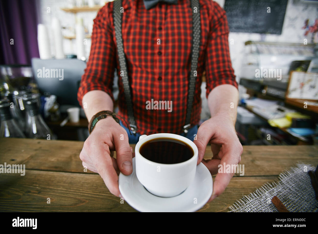 Barista offering you cup of black coffee Stock Photo - Alamy