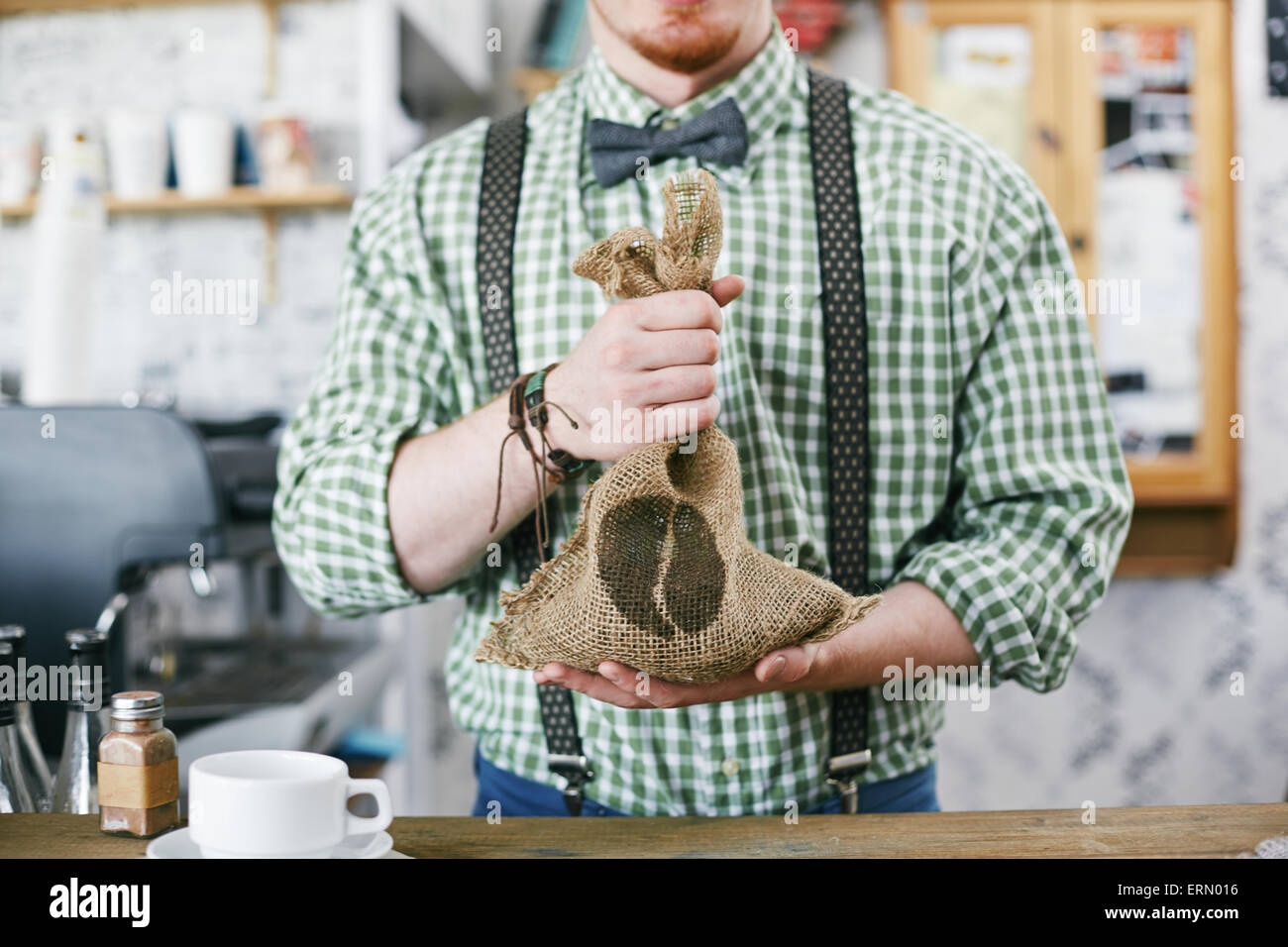 Barista holding sack with coffee grains Stock Photo - Alamy