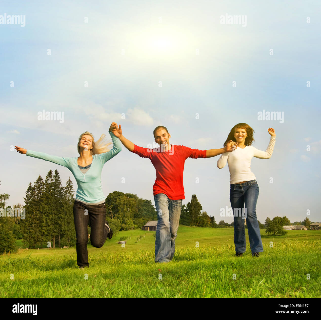 Three happy friends running outdoors Stock Photo - Alamy