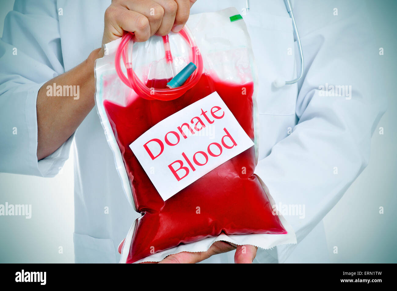 closeup of a doctor holding a blood bag with a sticker with the text ...