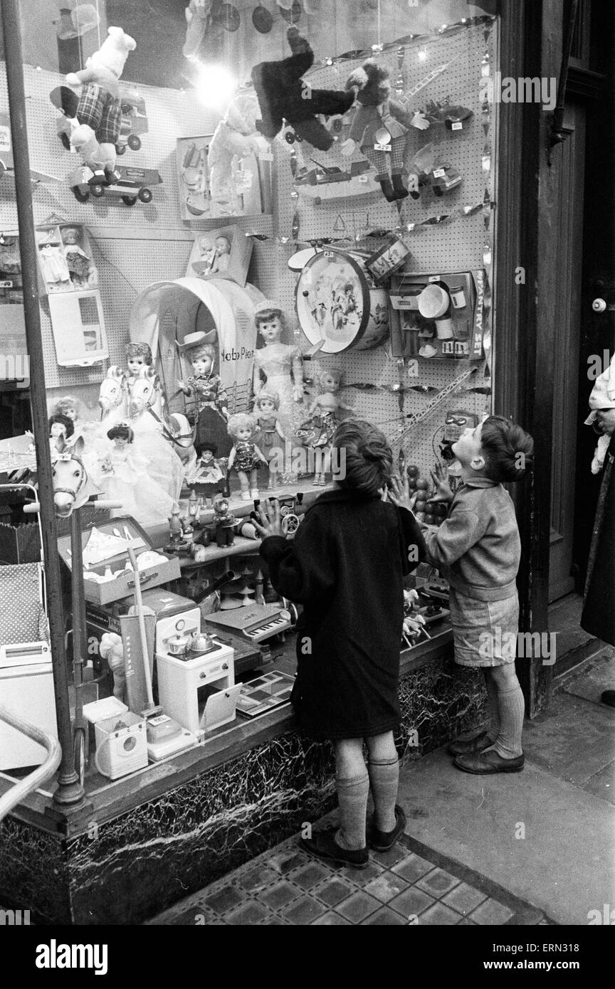 Children look longingly at toys into shop window at Christmas, 16th ...