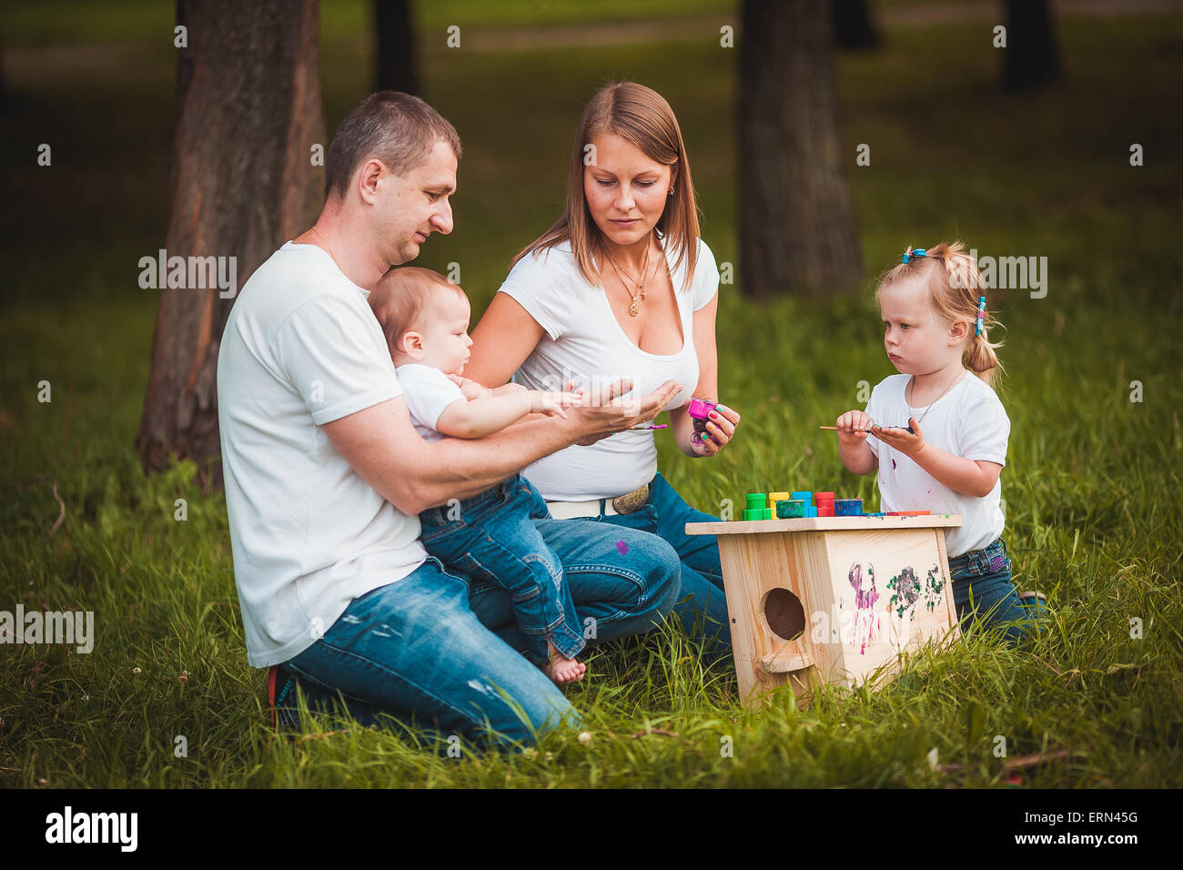 Happy family with nesting box and paints Stock Photo - Alamy