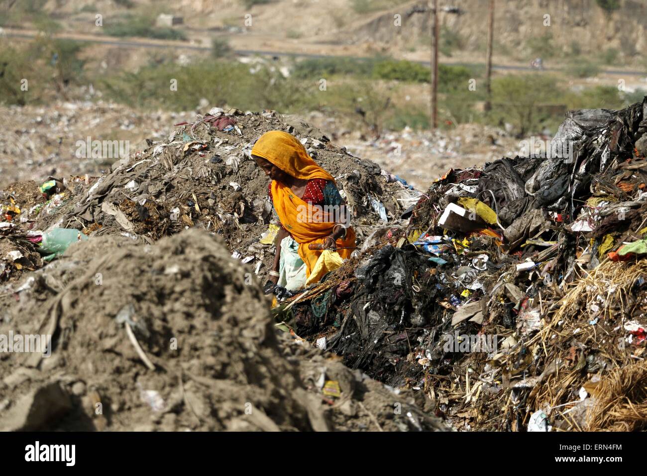 A woman searches for recyclable materials in a dumping site. The World ...