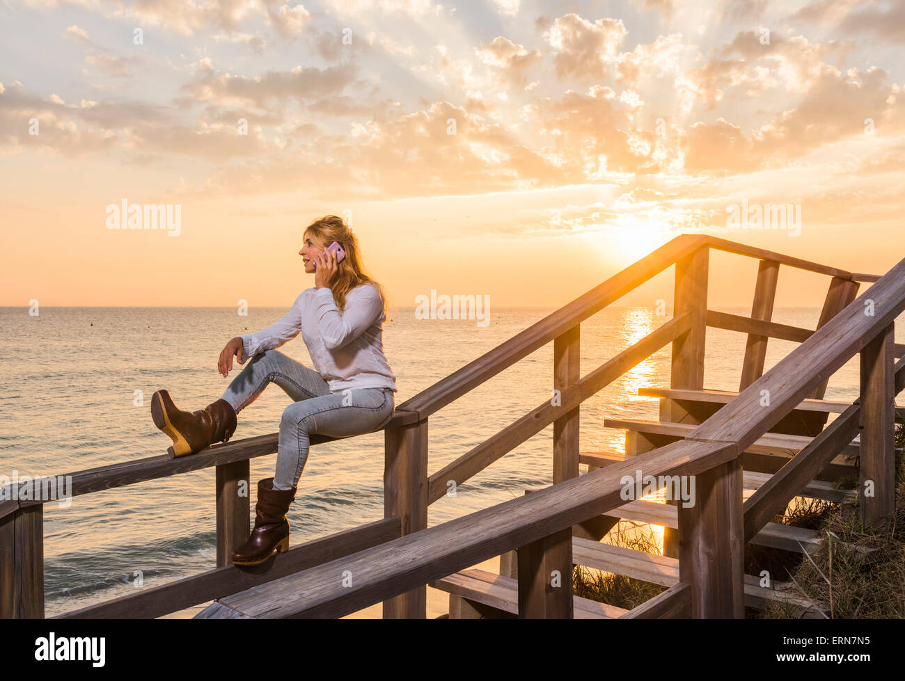 Woman sitting on the edge of a railing hi-res stock photography and ...
