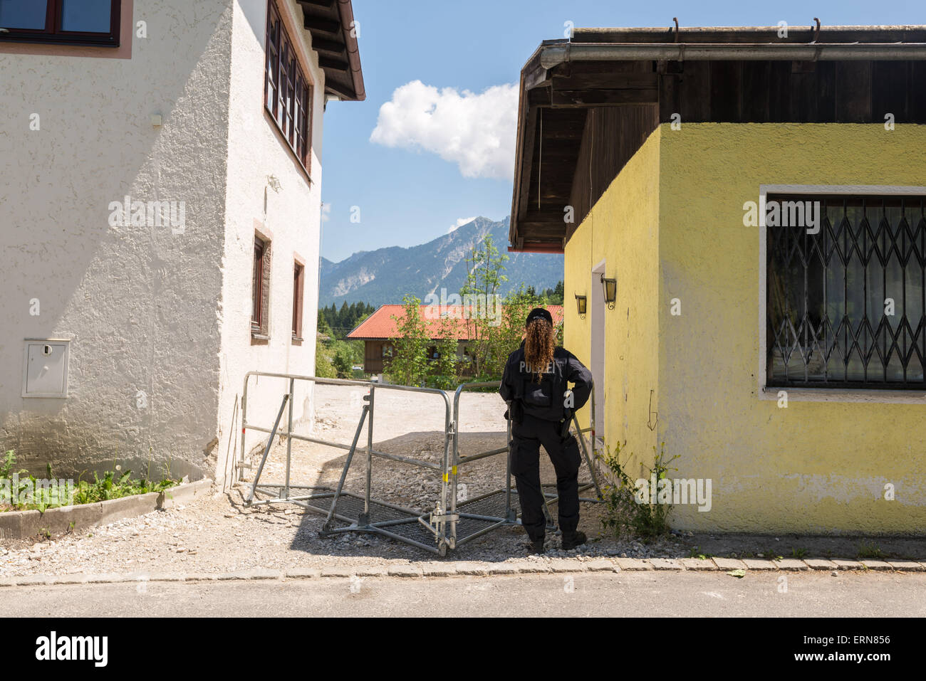 A police officer secures a small area between two houses with a view of ...