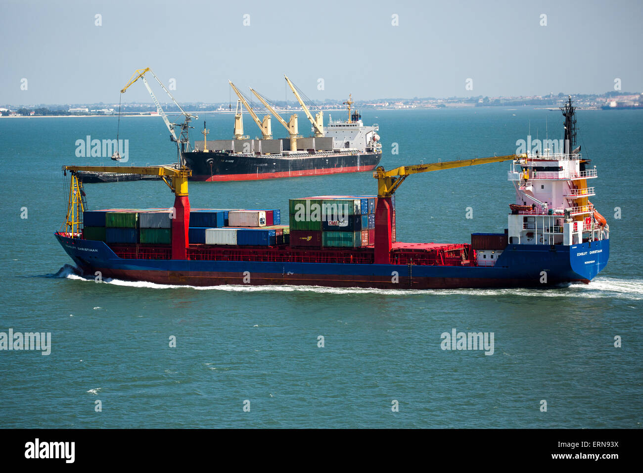busy Lisbon harbour. Container ship heading for berth passing bulk ...