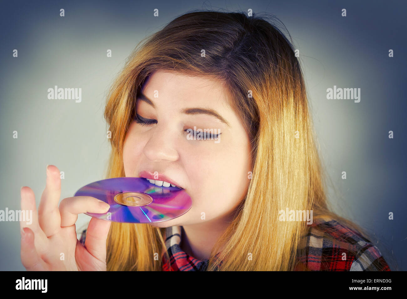 Young and cute female eating a DVD disk like a donut Stock Photo - Alamy