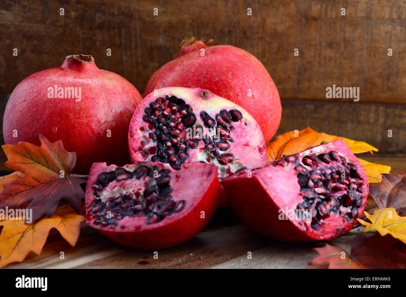 Stack of fresh pomegranates with cut slices on Autumn Fall leaves ...