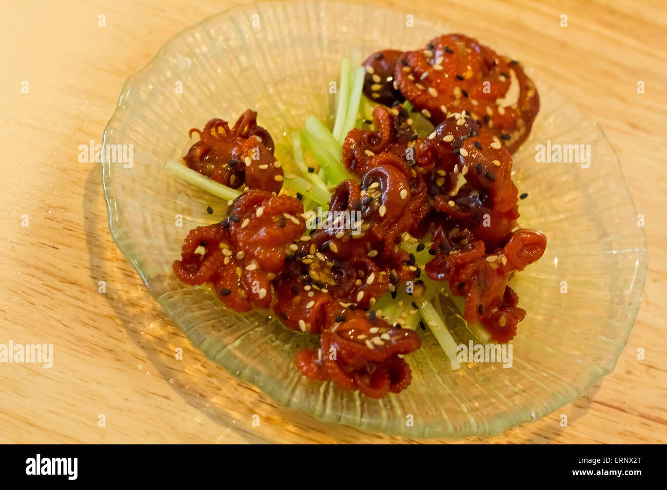 Japanese baby octopus in sesame soy sauce on bed of cucumbers Stock ...