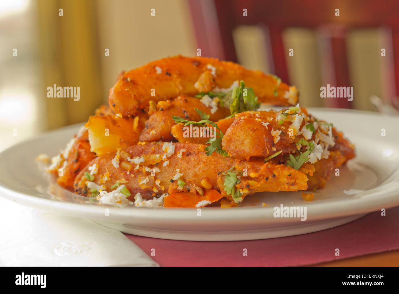 Spicy fried Indian potato wedges with coriander and coconut shavings ...