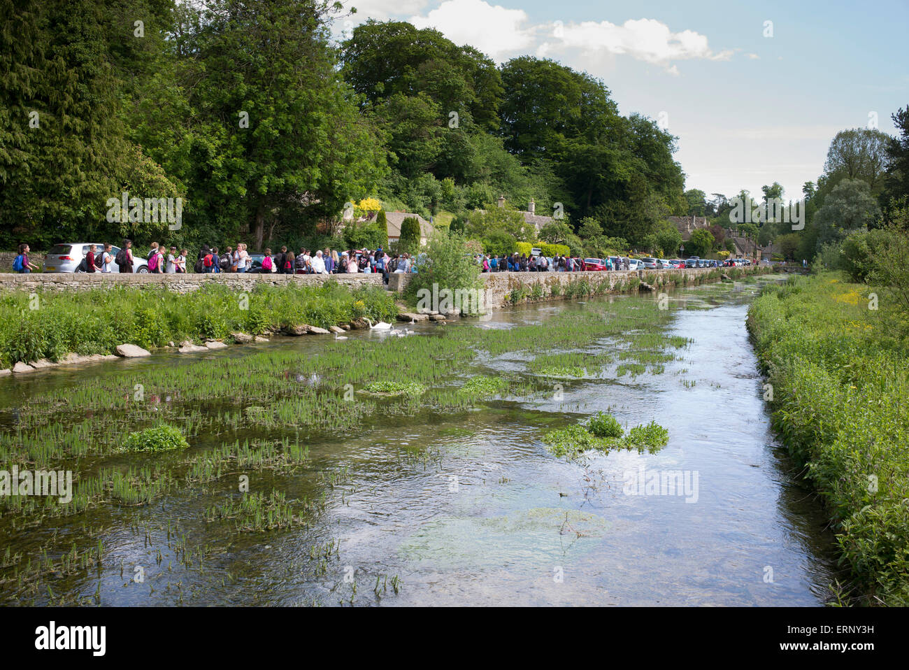 French school children walking along the River Coln in Bibury ...