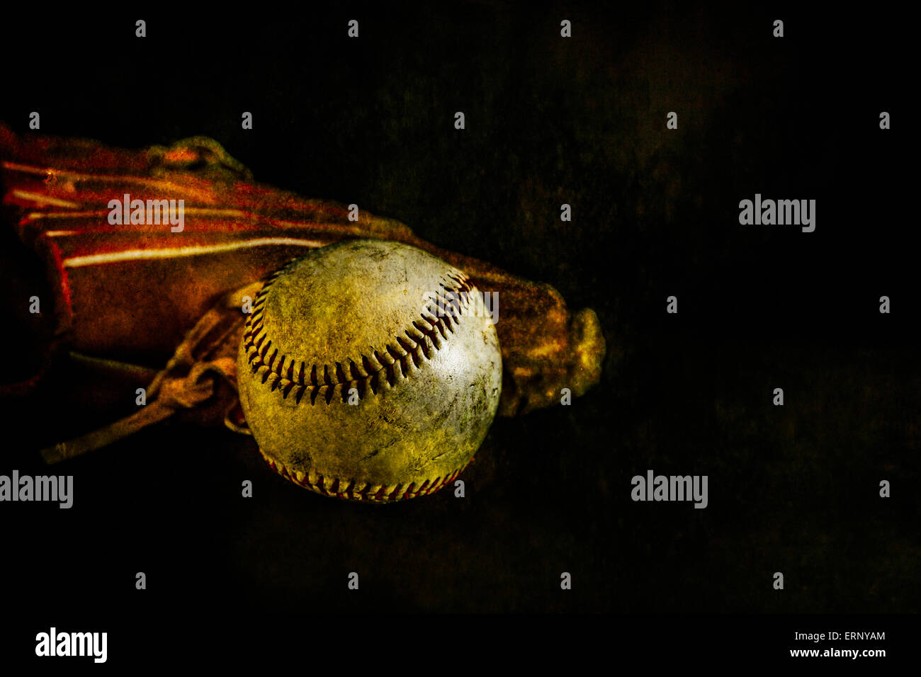 A rustic looking baseball sits in front of a glove - grunge background ...