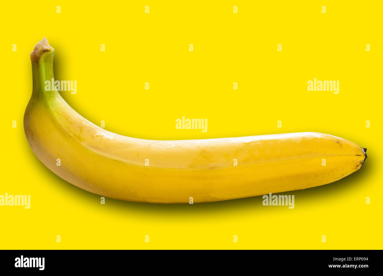 one ripe banana closeup on a yellow background Stock Photo - Alamy