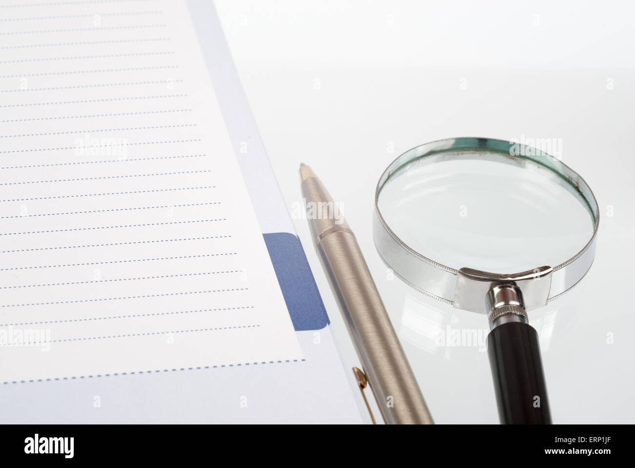 Hand glass and notebook Stock Photo - Alamy