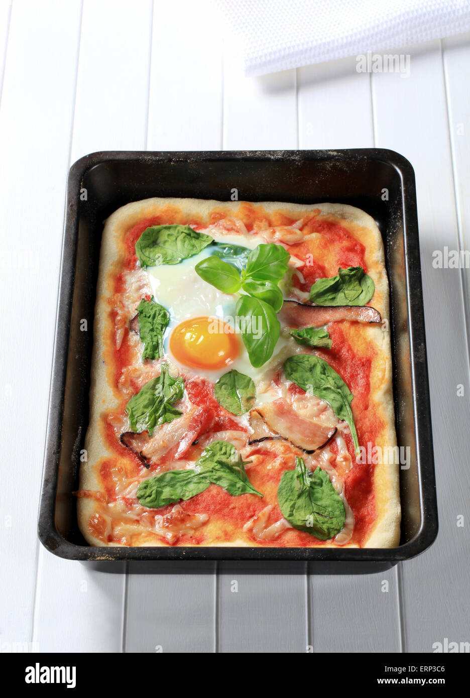 Bacon and egg pizza baked in a rectangular tray Stock Photo - Alamy