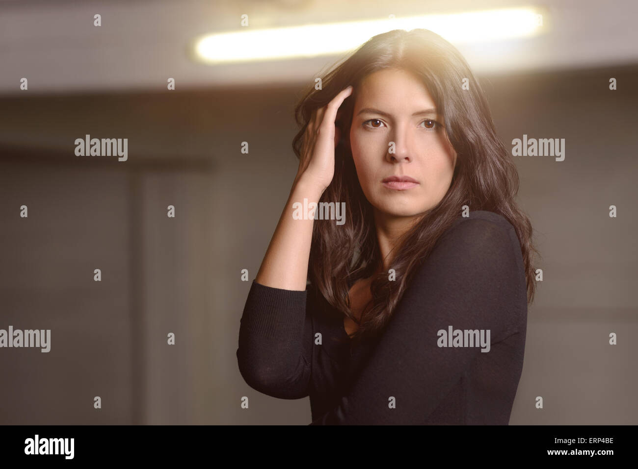 Serious attractive woman staring at the camera with an unemotional ...