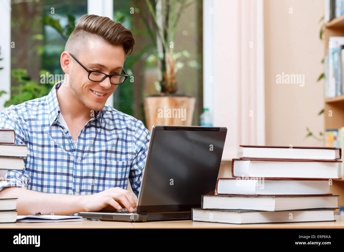 Young student working in a library Stock Photo - Alamy