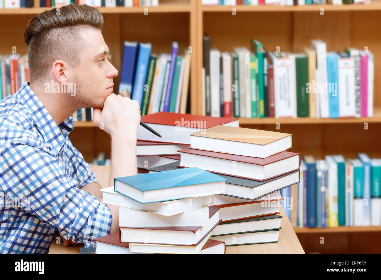 Young student working in a library Stock Photo - Alamy