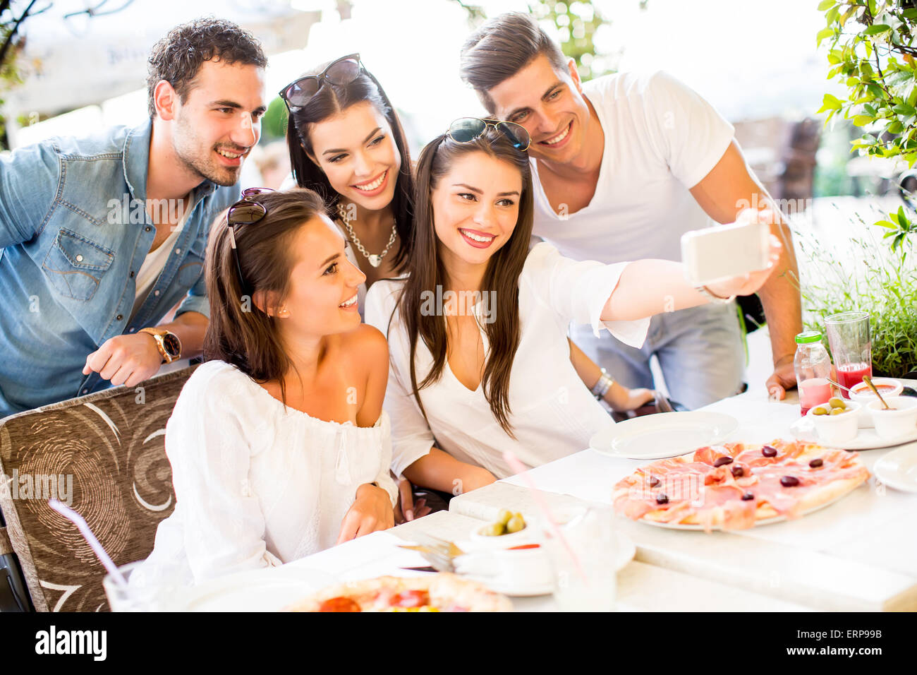 Young people taking photo by the table Stock Photo - Alamy