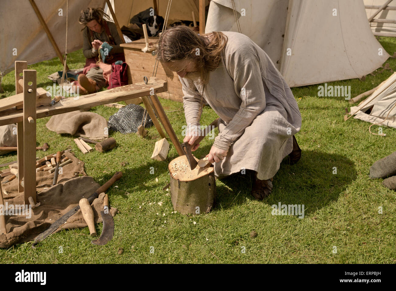 a man showing how to chop wood in Viking re-enactment village Stock ...