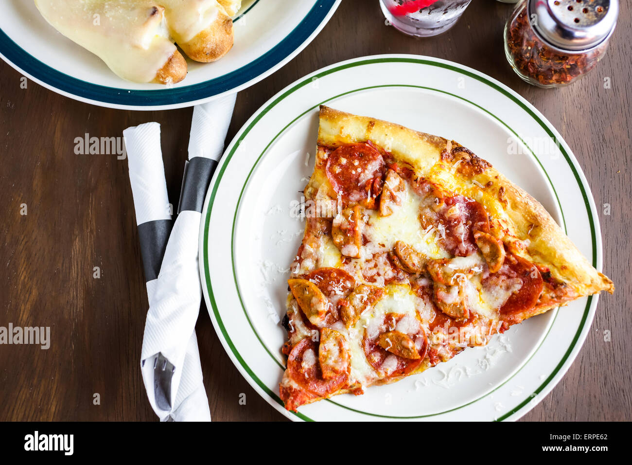 Fresh pepperoni and sausage pizza slice on the table in Italian ...