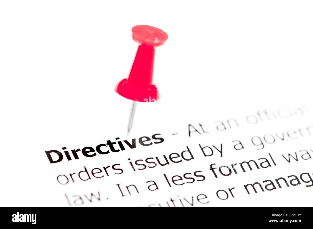 Word DIRECTIVES pinned on white paper with red pushpin, available copy ...