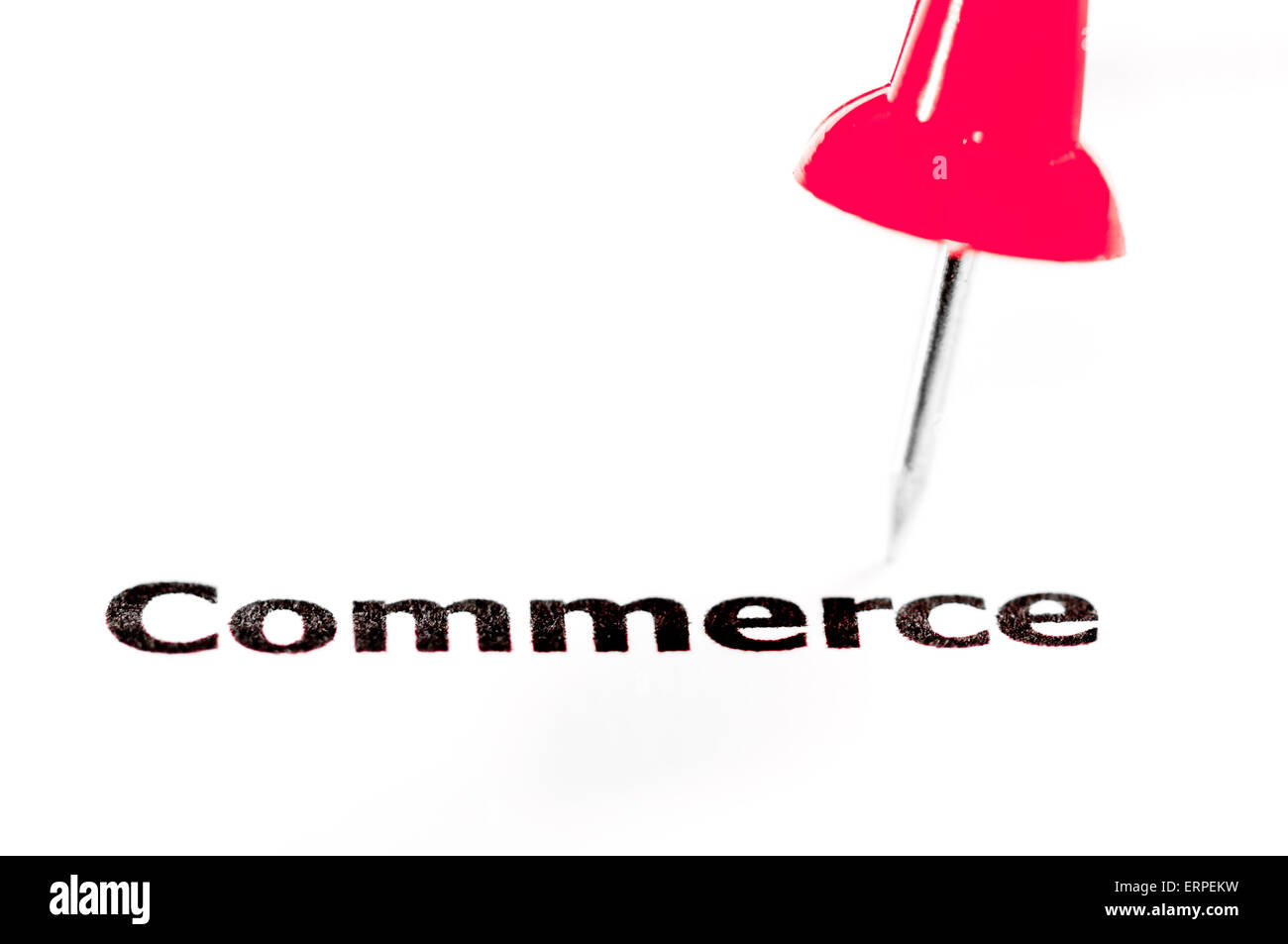 Word COMMERCE pinned on white paper with red pushpin, available copy ...