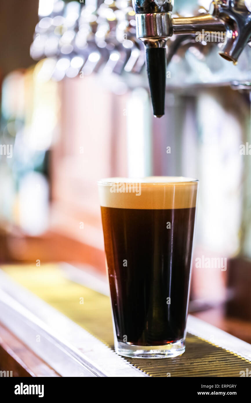 Bartender pouring draft beer in the bar Stock Photo - Alamy