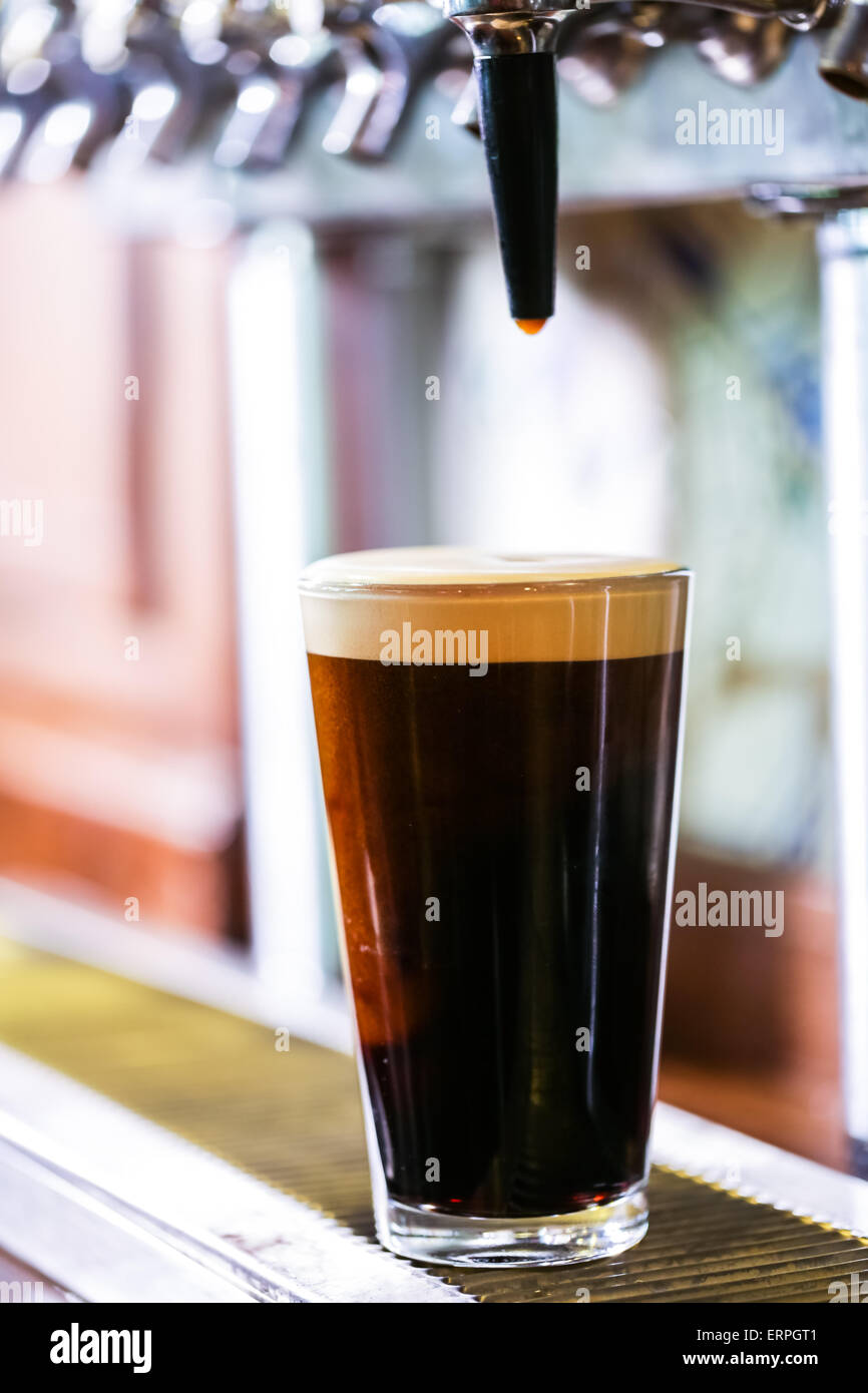 Bartender pouring draft beer in the bar Stock Photo - Alamy