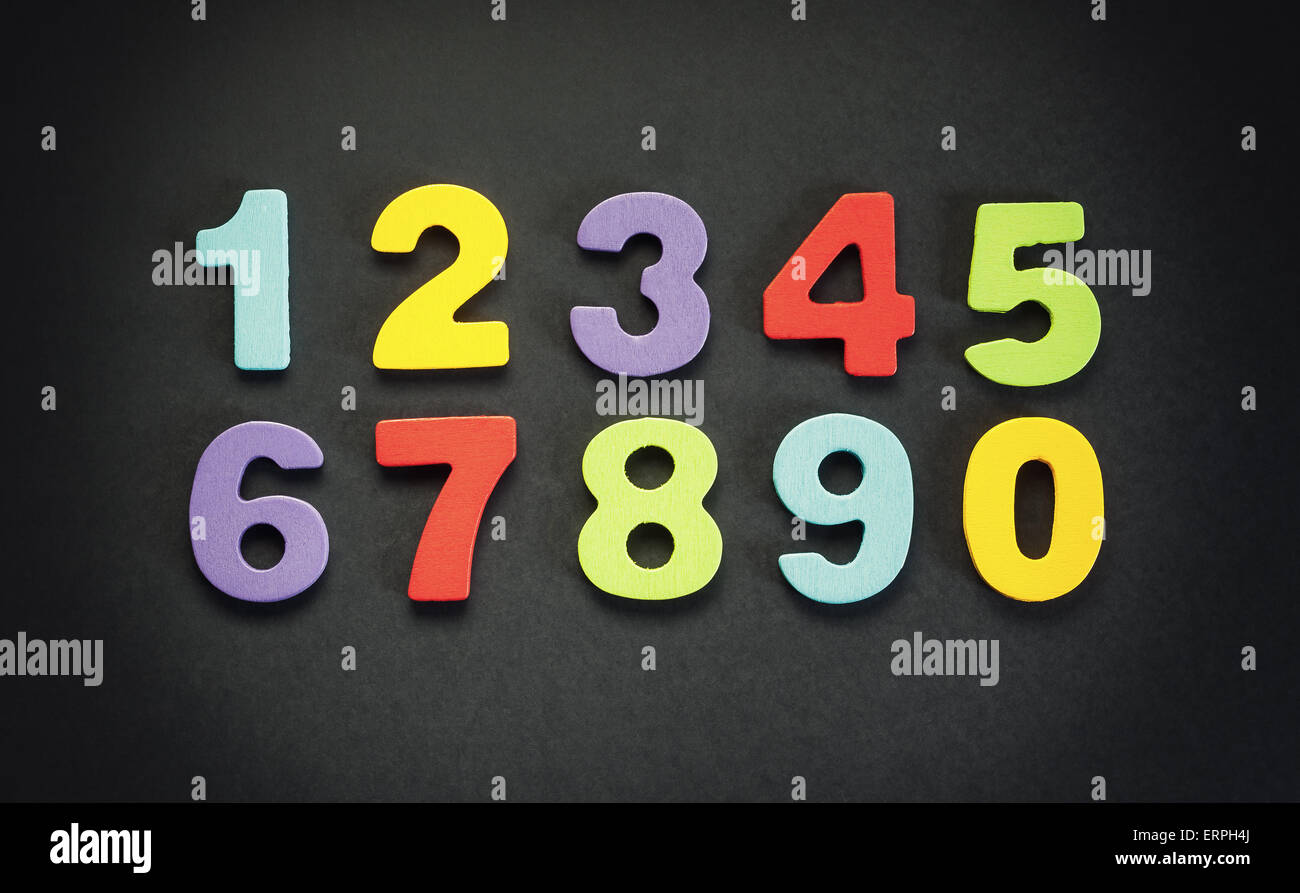 Wooden numbers in various colors, in two rows on black background Stock ...