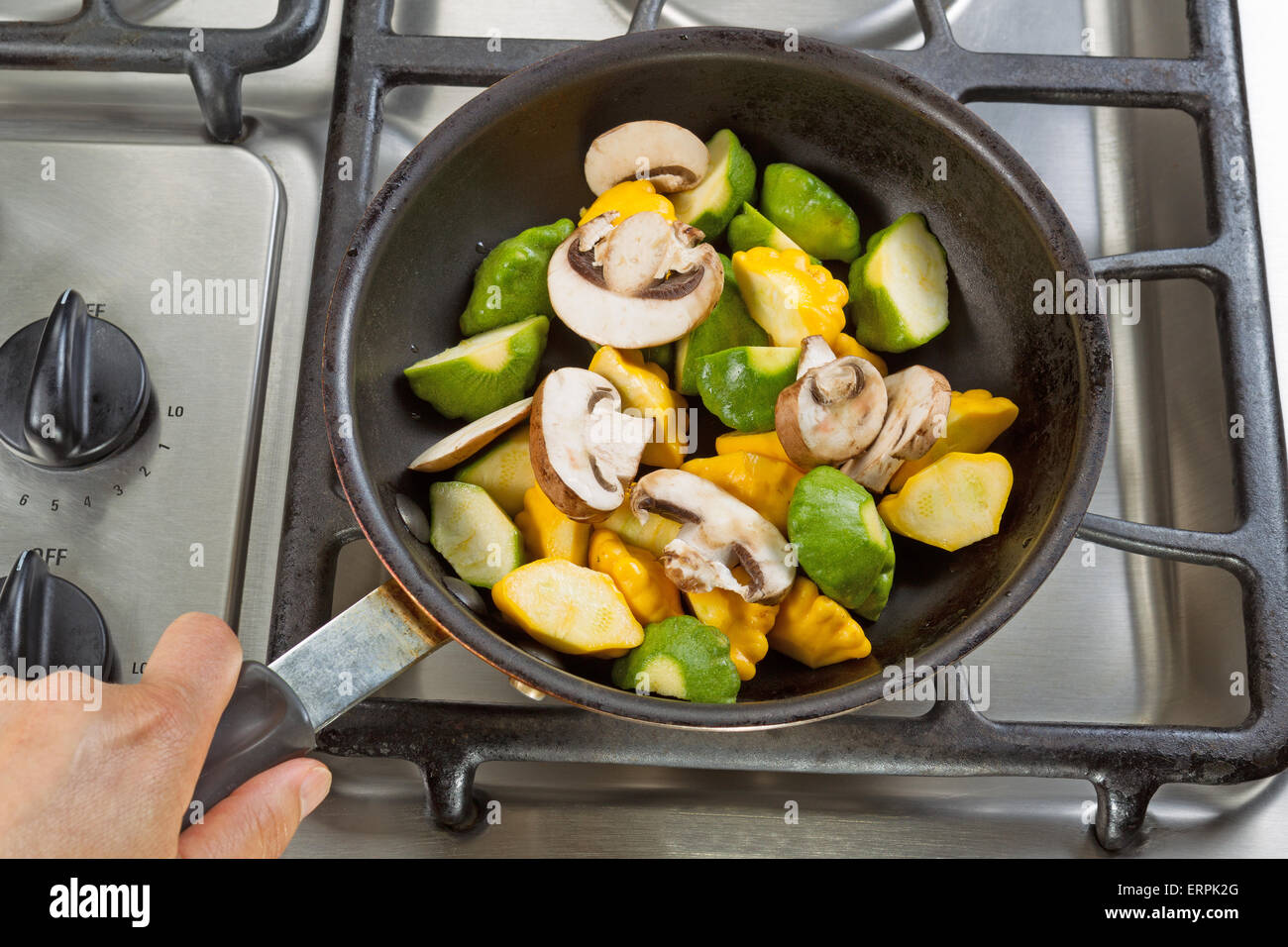 Close up of hand holding frying pan, focus on food, while cooking ...