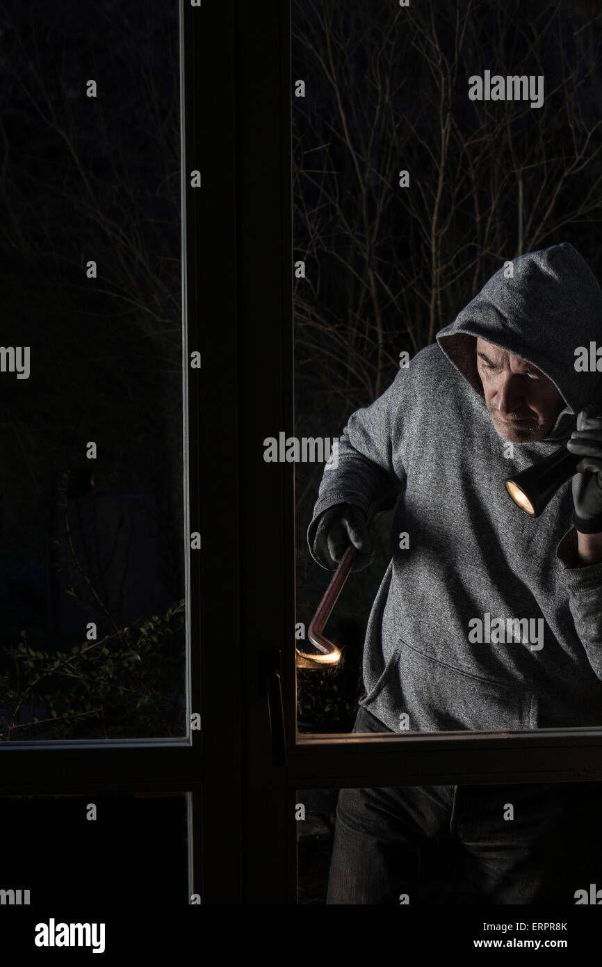 MODEL RELEASED. Man breaking into building Stock Photo - Alamy