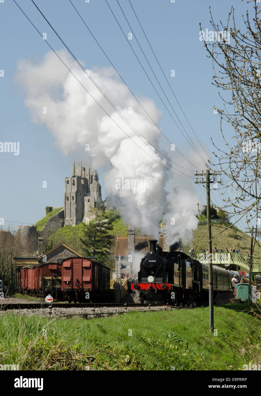 Steam train leaving the station at Corfe. Corfe Castle in background ...
