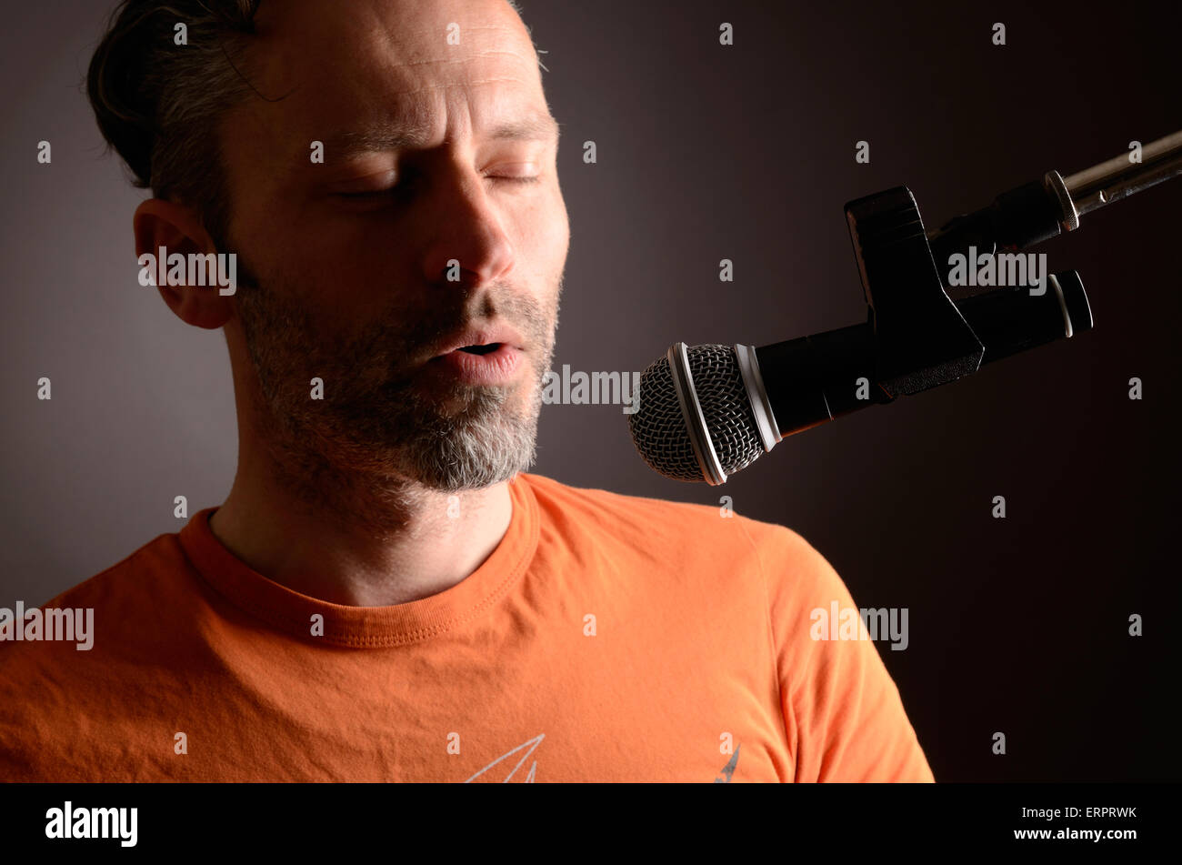 A man with a microphone in a studio Stock Photo - Alamy