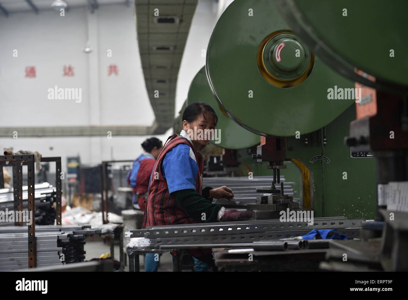 A female labor works at a factory to produce steel tools for scaffold ...