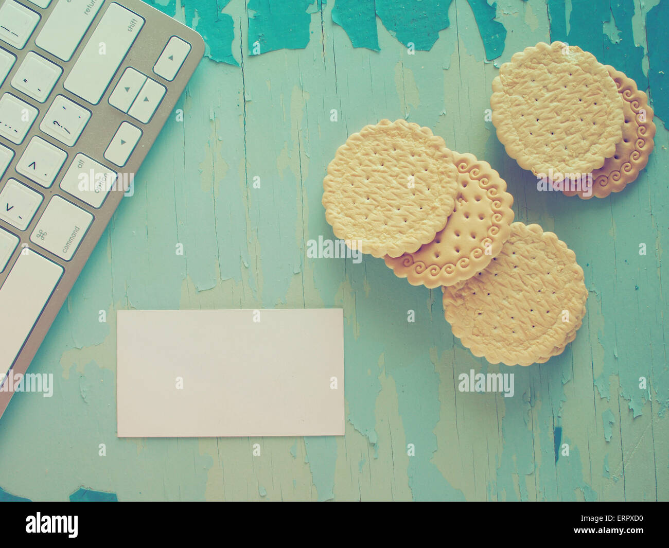 Computer keyboard, biscuits and empty business card on blue painted ...